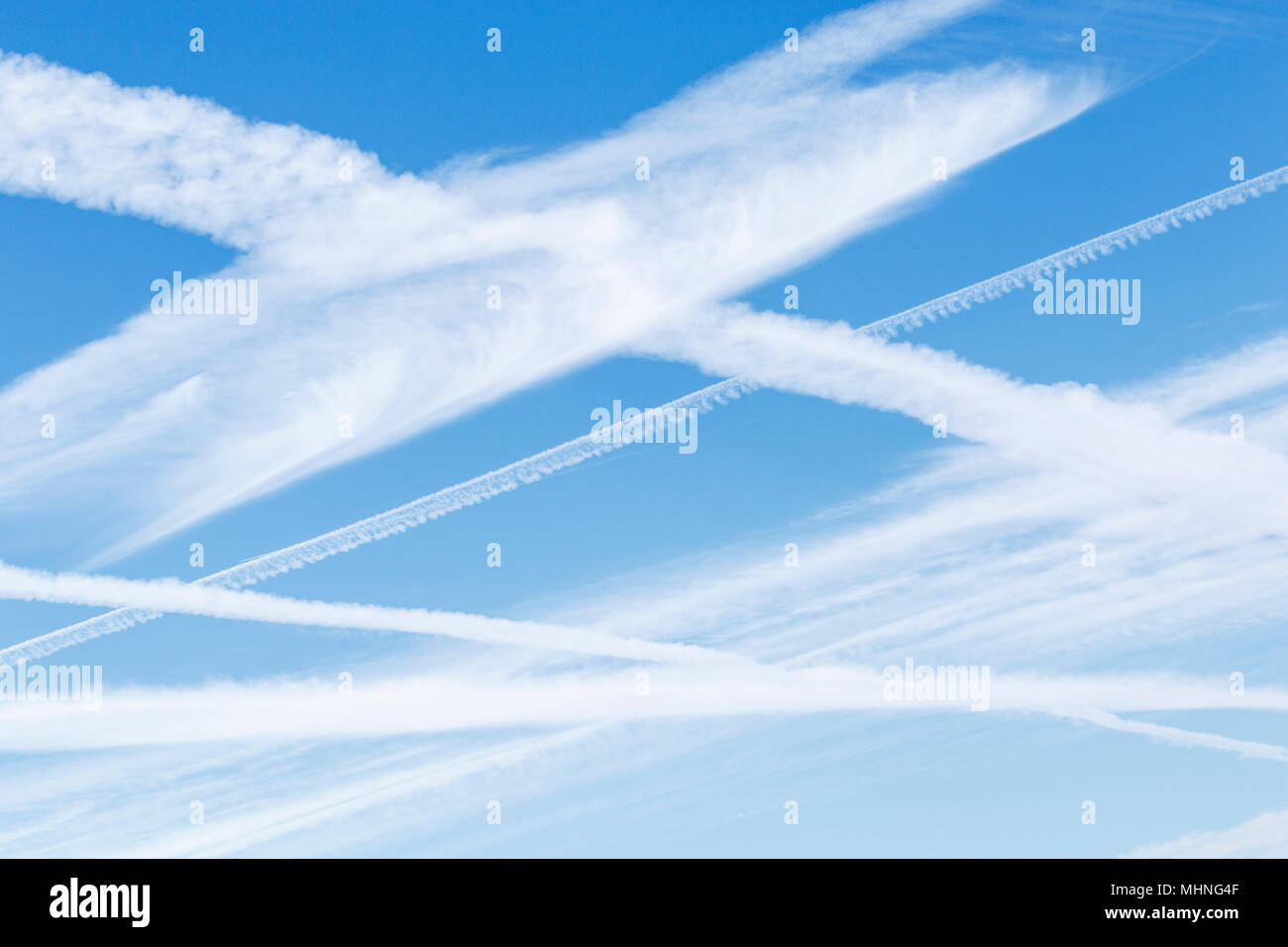 Plane traces, cloud lines in blue sky Stock Photo - Alamy