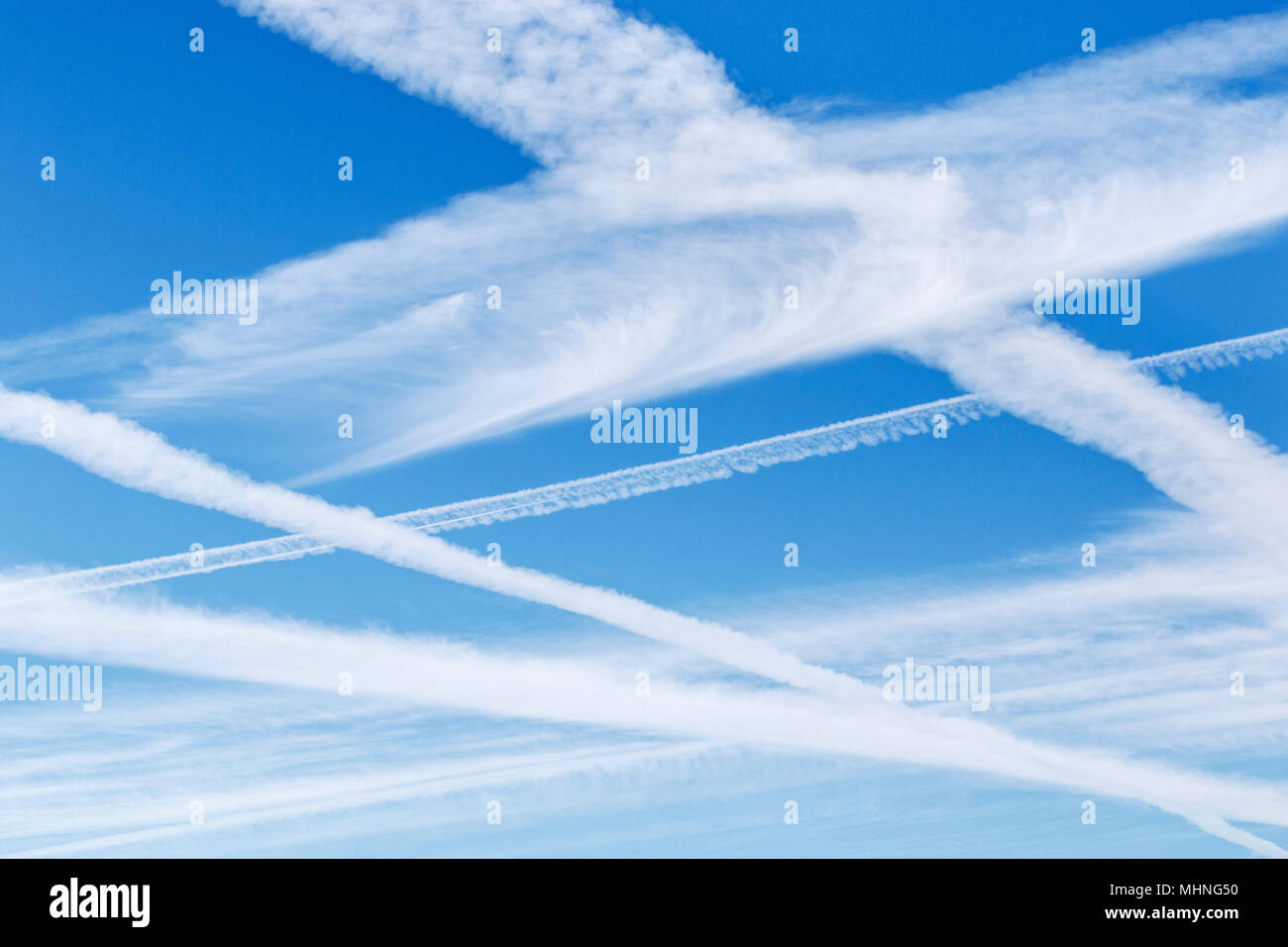 Plane traces, cloud lines in blue sky Stock Photo - Alamy