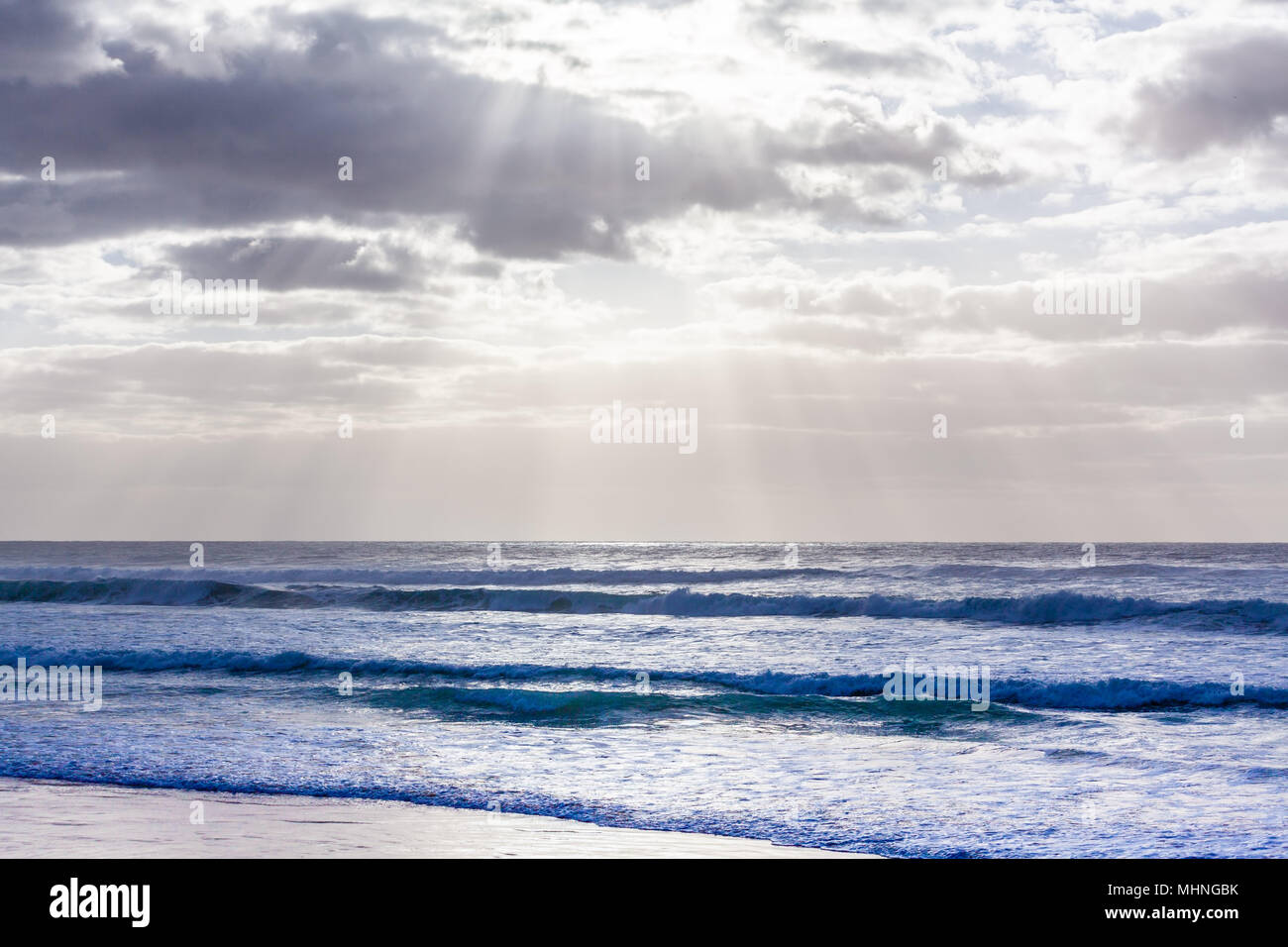 Beautiful seascape with sun rays through clouds and ocean waves Stock ...