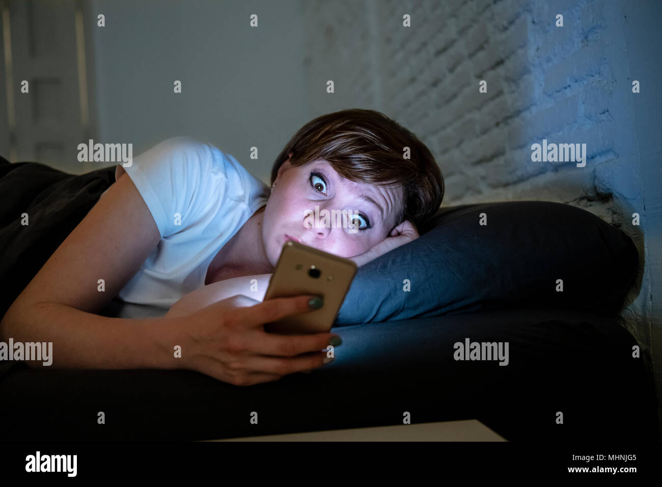 Looking at phone in bed at night hi-res stock photography and images ...