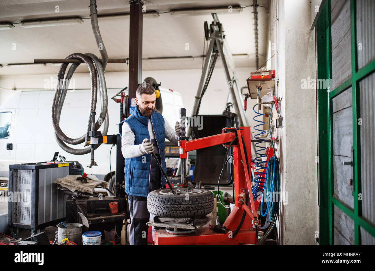 Man mechanic repairing a car in a garage Stock Photo - Alamy