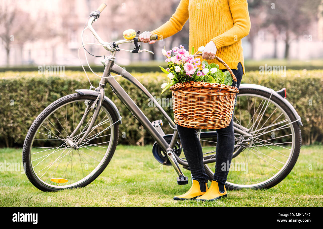 Young woman with bicycle standing outside in sunny spring Stock Photo ...
