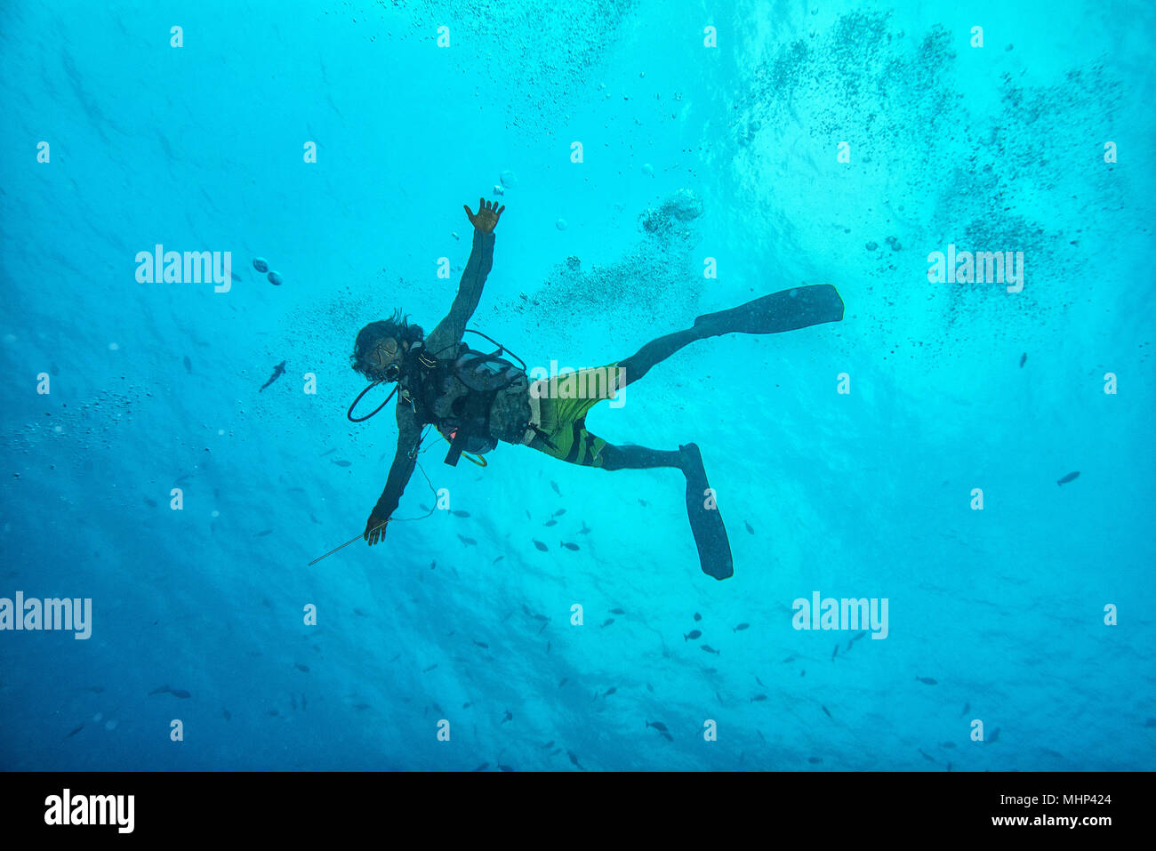 crazy Scuba diver underwater in the deep blue ocean and backlight sun ...