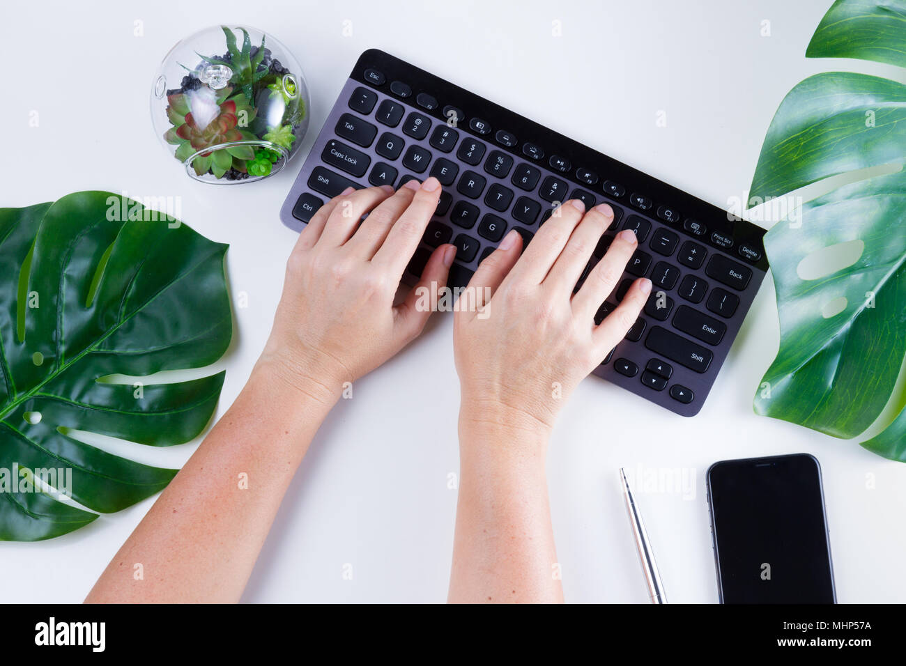 Flat lay home office workspace with someones hands typing on black ...