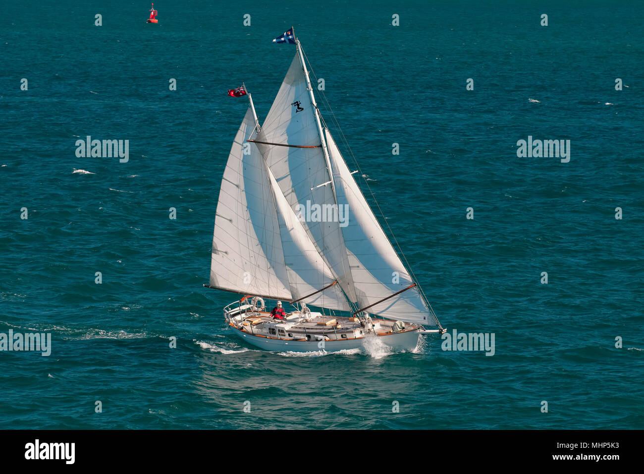 A boat with solitary captain sailing in the blue sea Stock Photo - Alamy