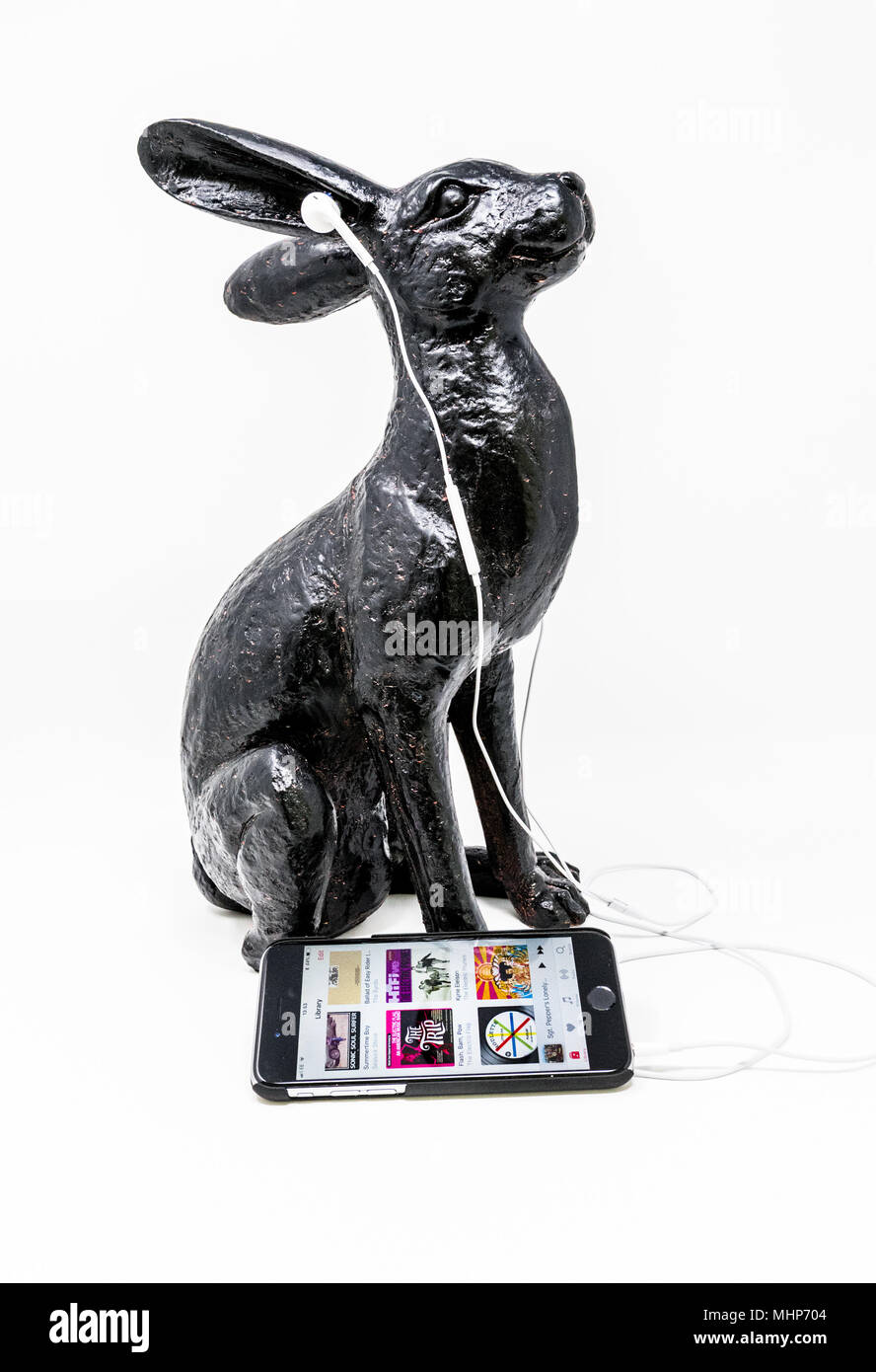 Black painted brass model of an Hare with iphone and earpods Stock ...