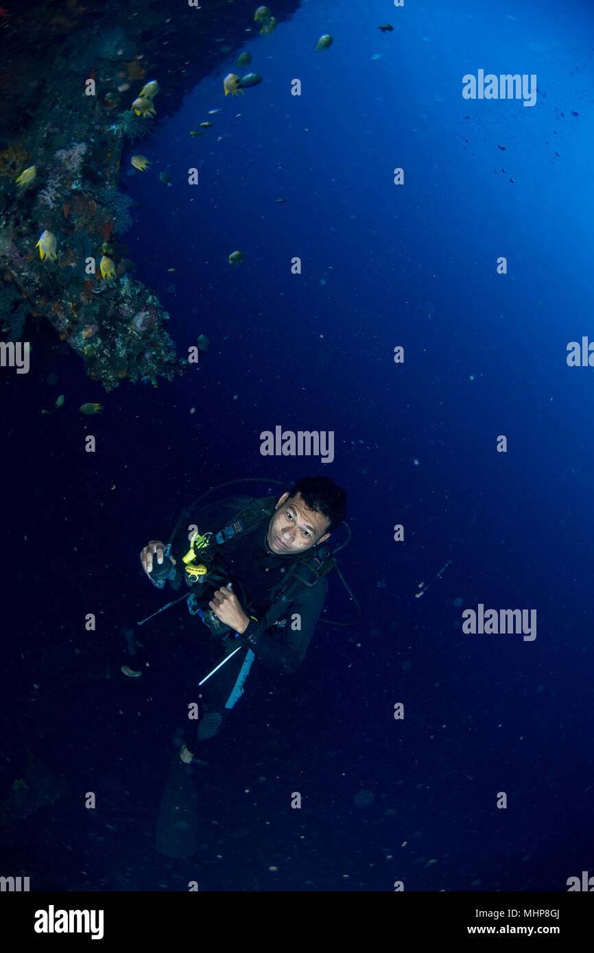 Scuba diver underwater portrait in the deep blue ocean and backlight ...