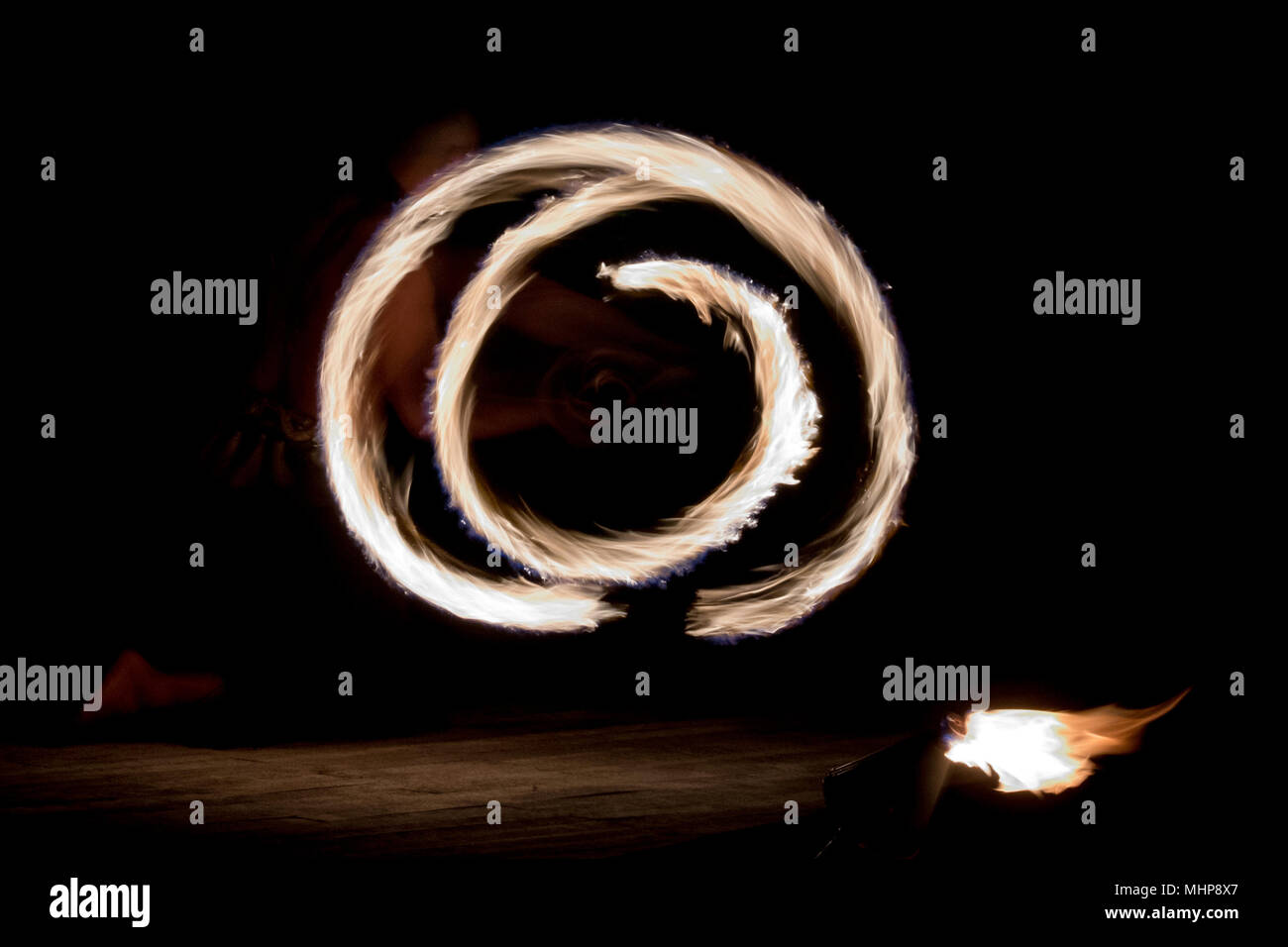 polynesian dancer using flame pole on black background Stock Photo - Alamy