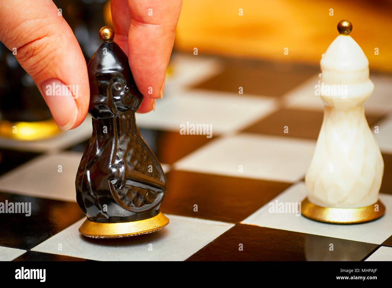 Person fingers with black pawn making move on chess board. Close-up ...