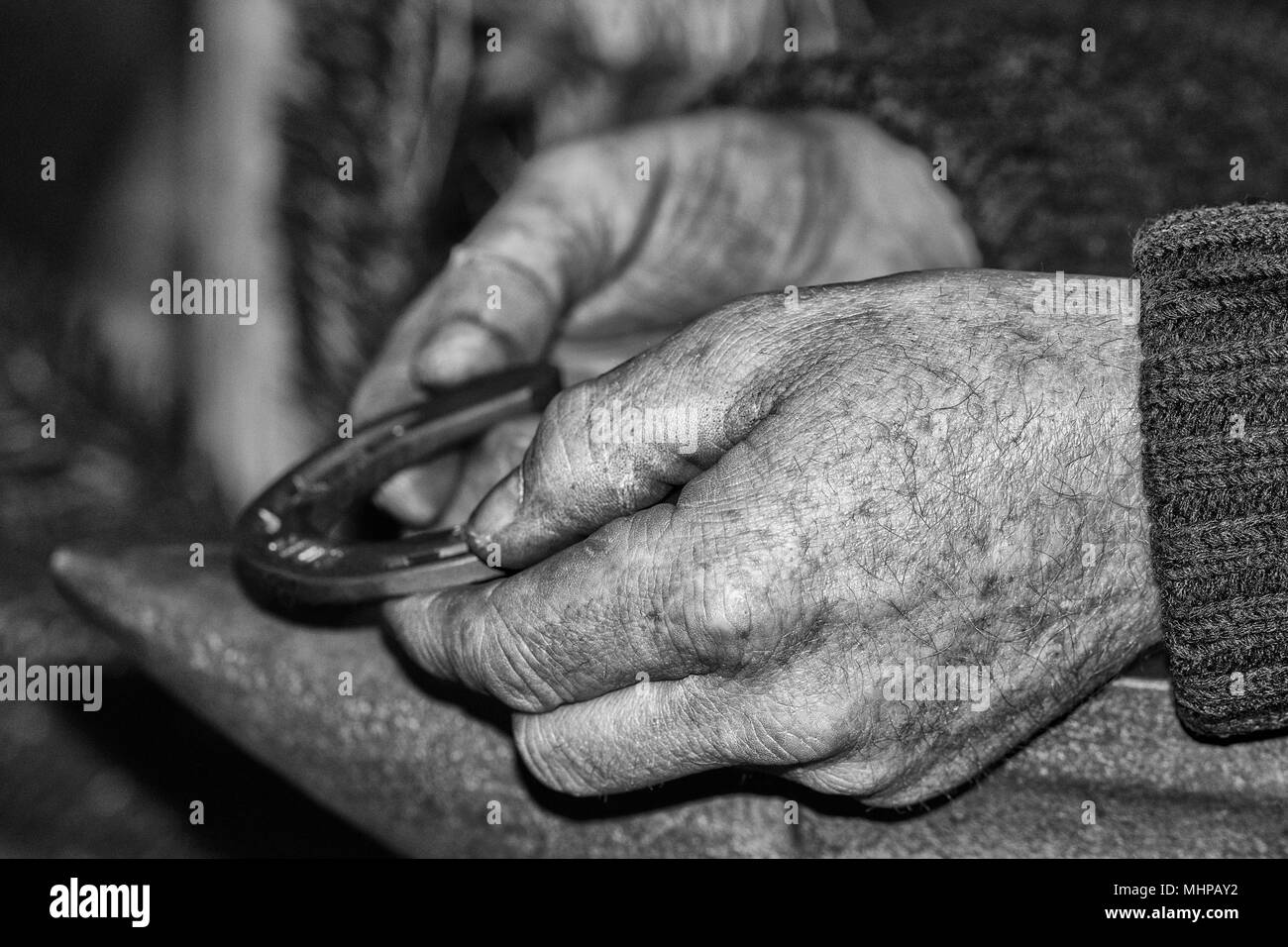 old retired man hand detail while working iron in black and white Stock ...