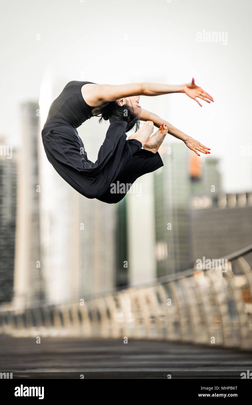 Jump... Passionate Young woman athlete performs a perfect leap high up ...