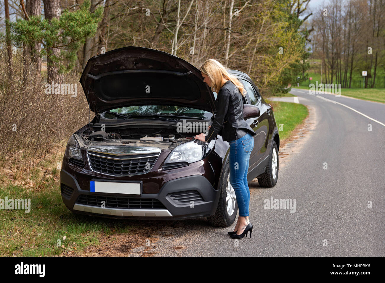 young attractive desperate and confused woman stranded on roadside ...