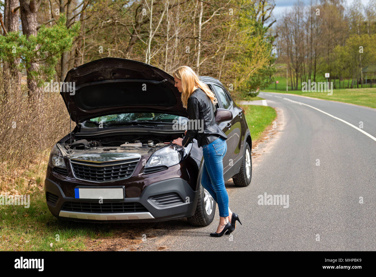 young attractive desperate and confused woman stranded on roadside ...