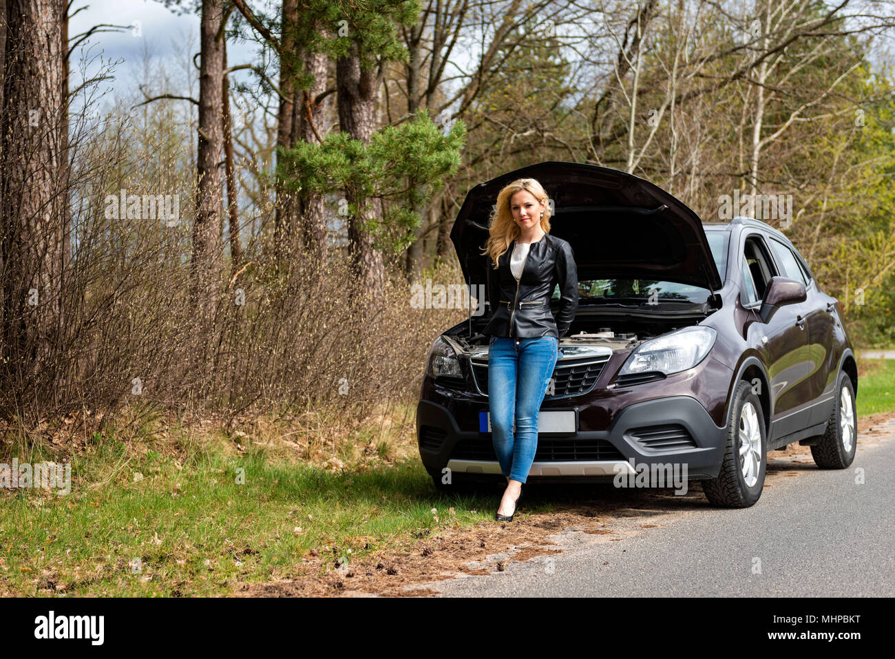 young attractive desperate and confused woman stranded on roadside ...