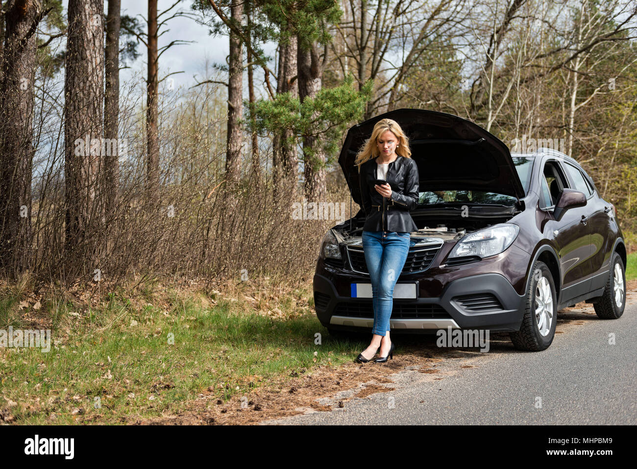 young attractive desperate and confused woman stranded on roadside with ...