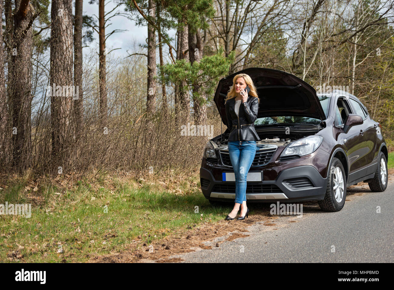 young attractive desperate and confused woman stranded on roadside with ...