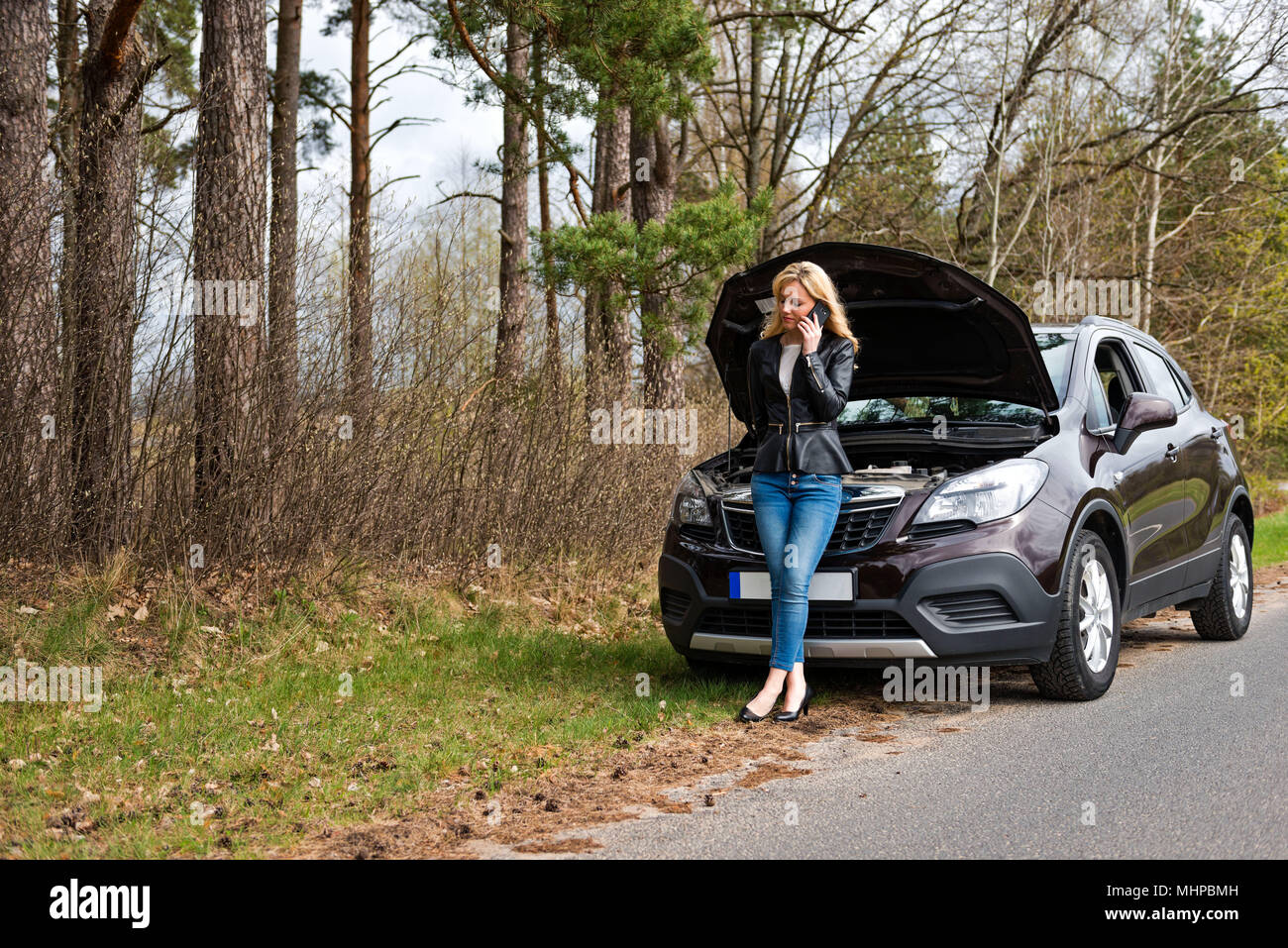 young attractive desperate and confused woman stranded on roadside with ...