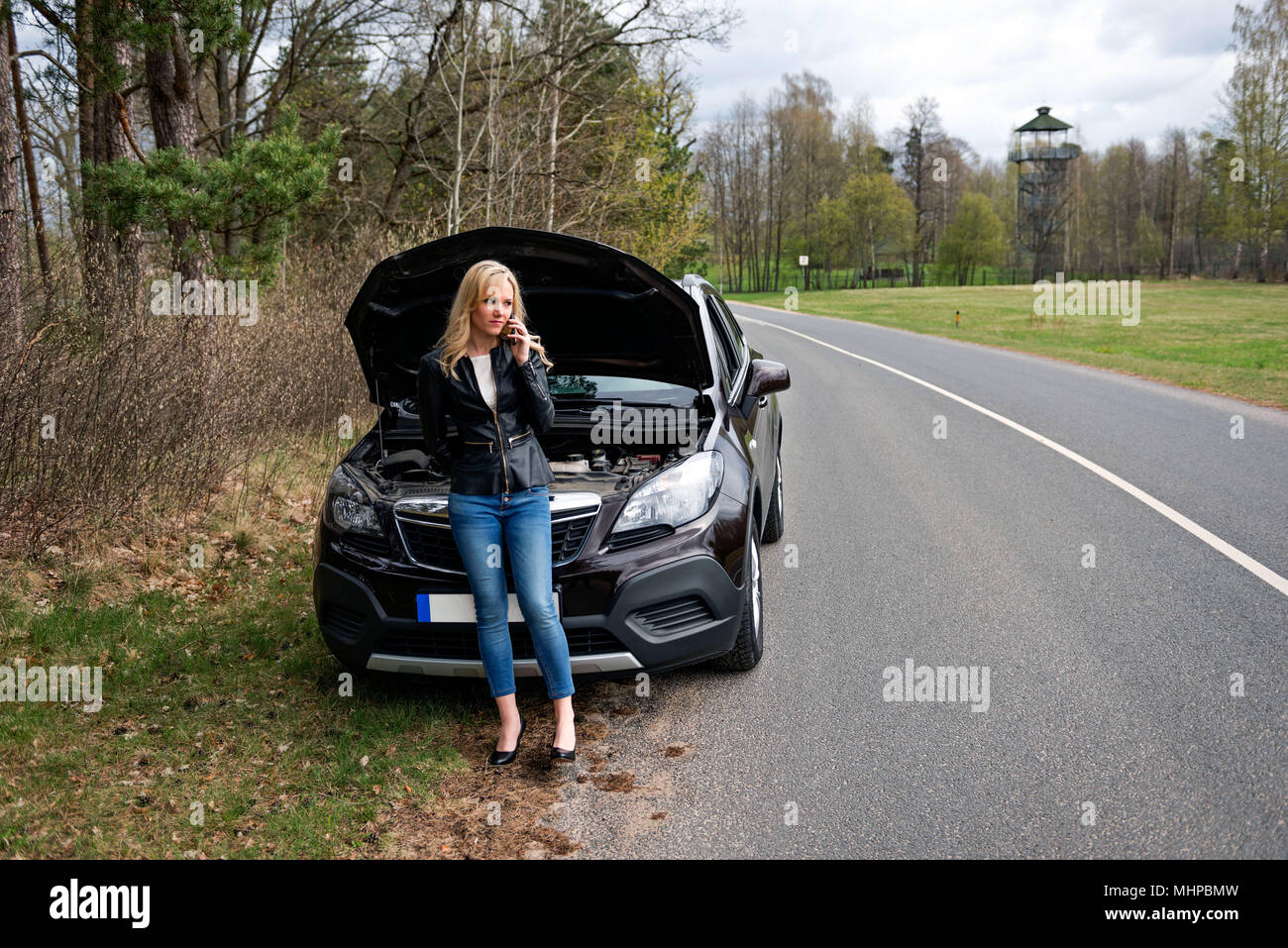young attractive desperate and confused woman stranded on roadside with ...