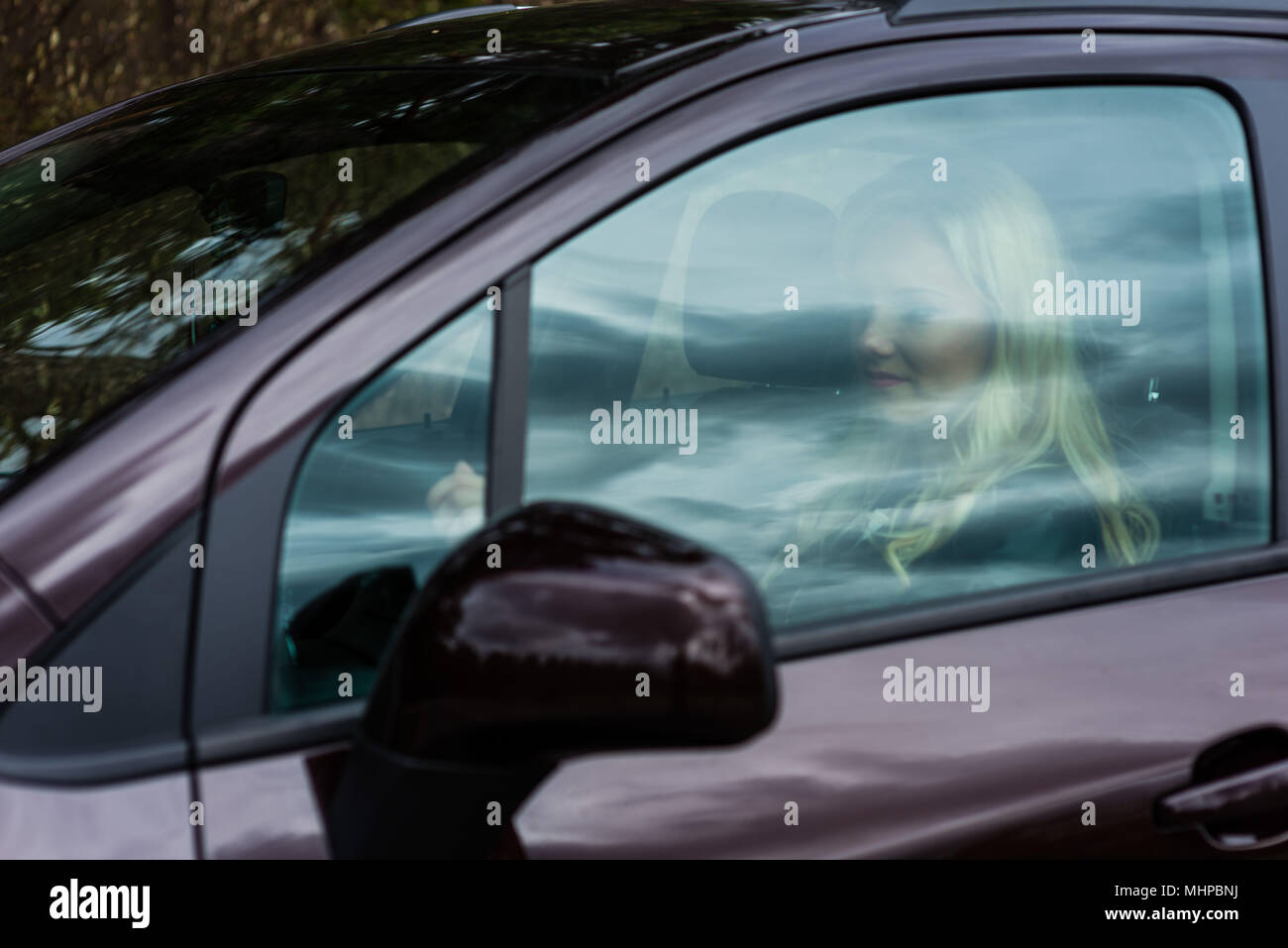 Woman looking through the car side window glass Stock Photo - Alamy