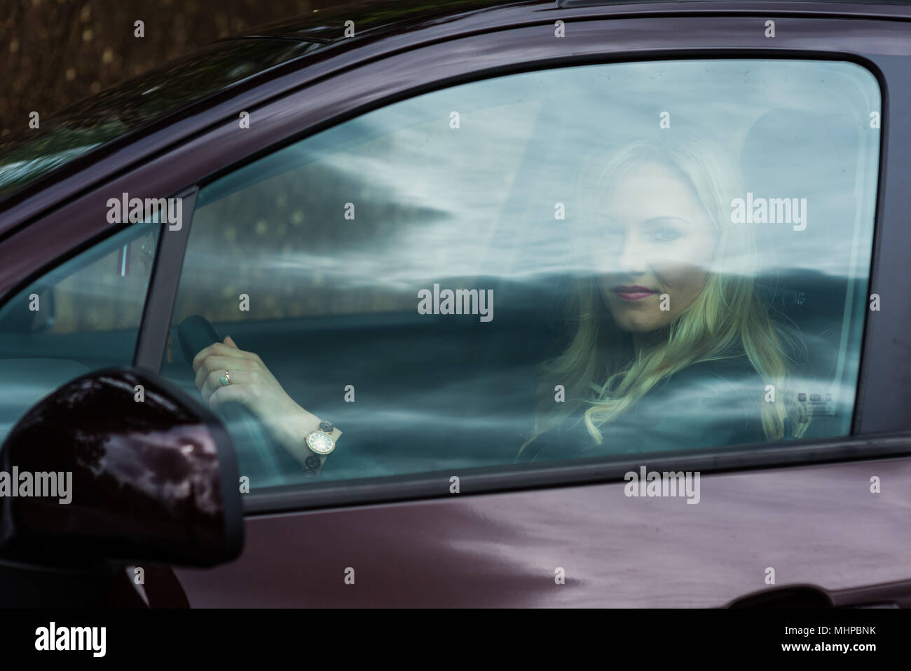 Woman looking through the car side window glass Stock Photo - Alamy