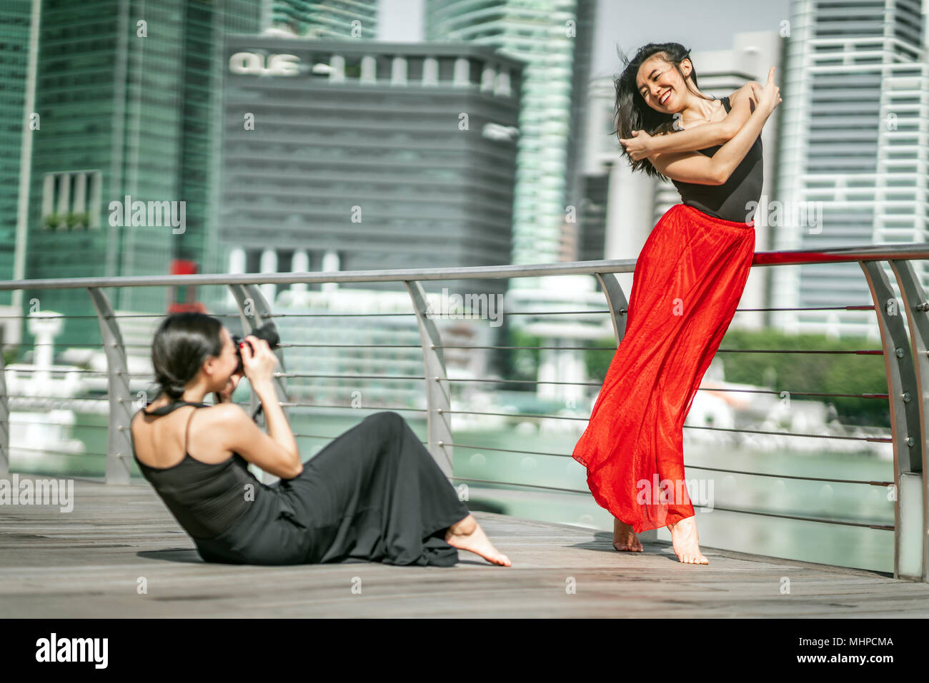 Two beautiful young girls having fun photo shooting on a deck with ...