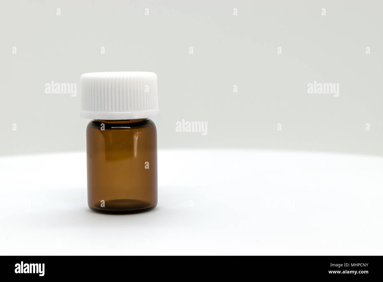 One brown sample bottle with white cap on white background with free ...
