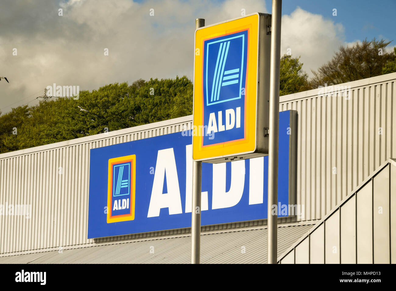 Large sign above the entrance to an Aldi supermarket in a retail park ...