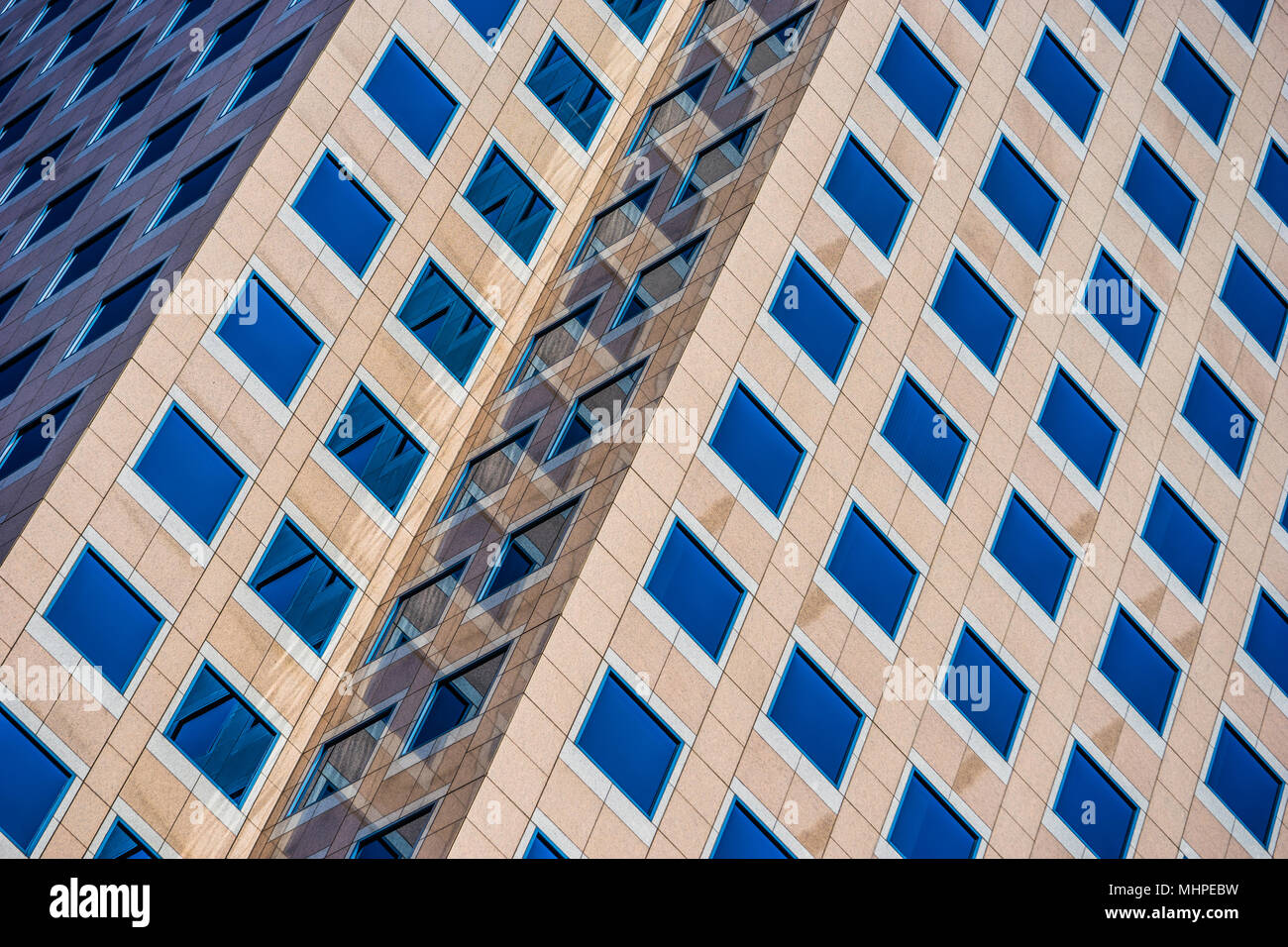 Angled lines and shaded facades of a modern architectural highrise ...