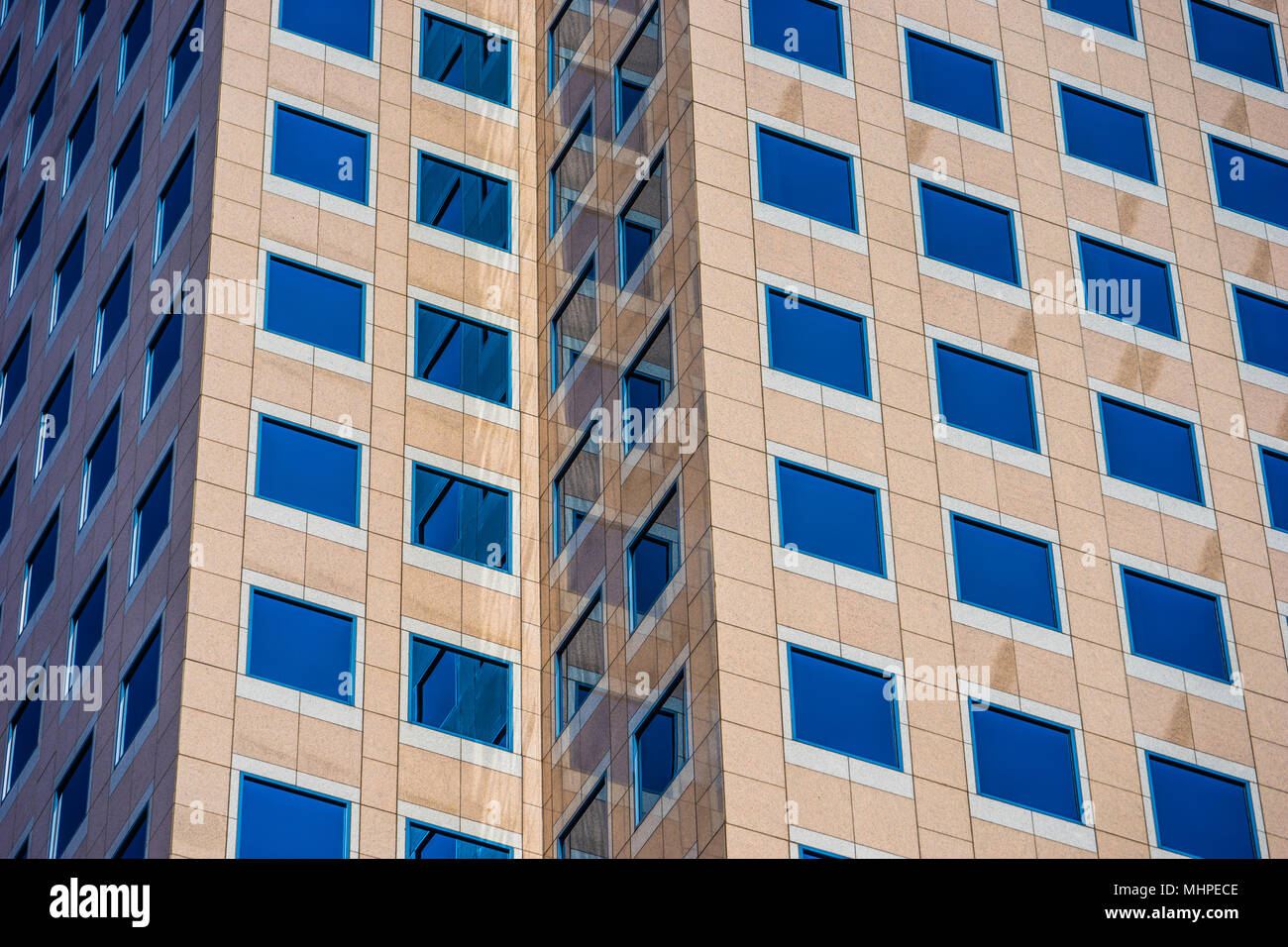 Dozens of windows form the angled facade of a modern skyscraper ...