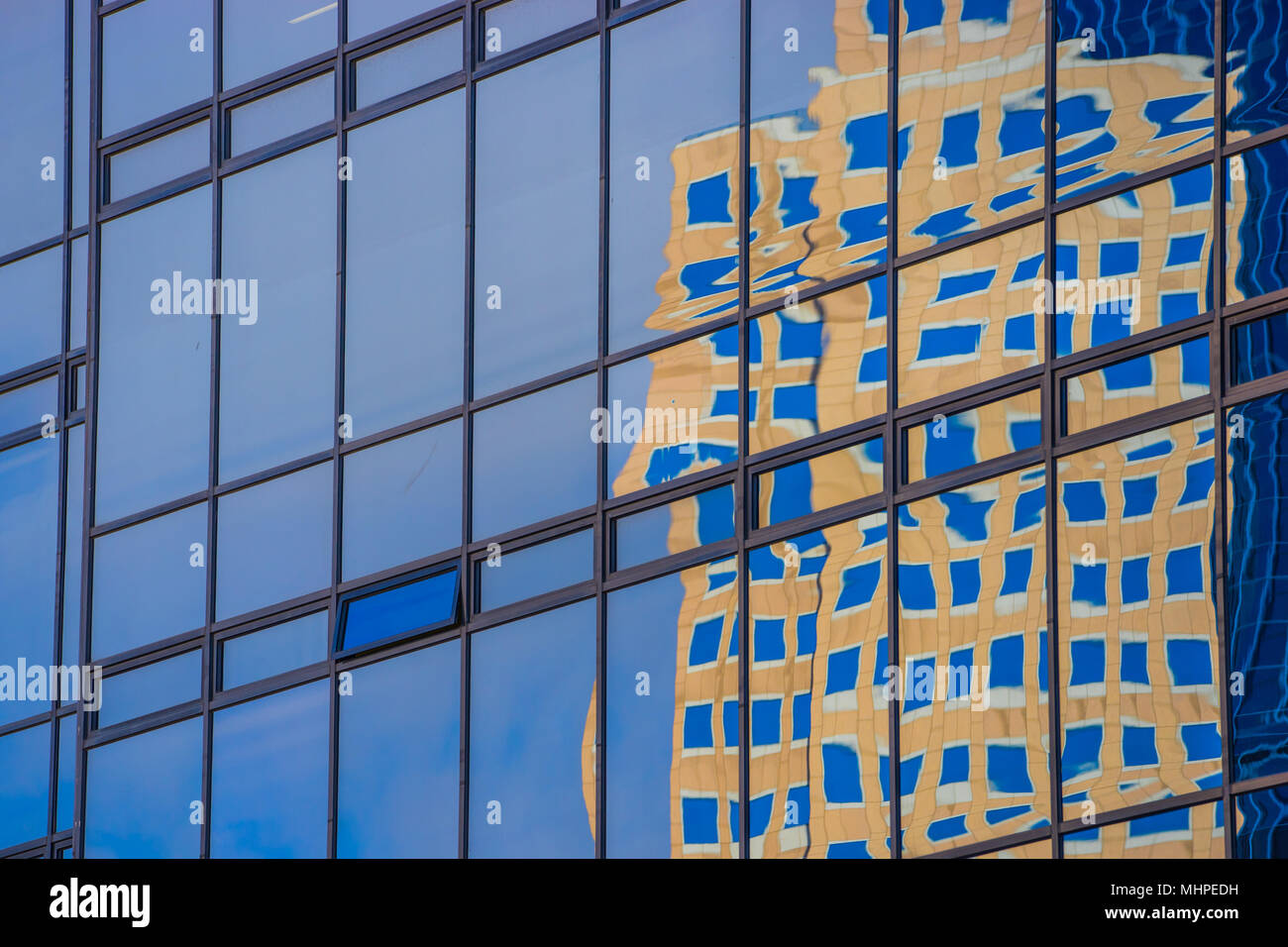 Warped view of reflected building seen in the glass and metal of ...
