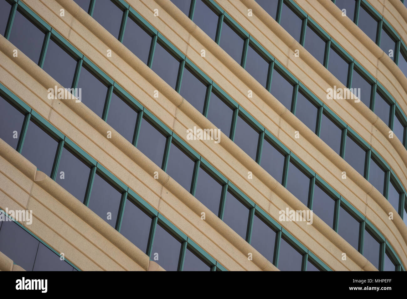 Lines of framed glass and cement form facade of downtown highrise ...
