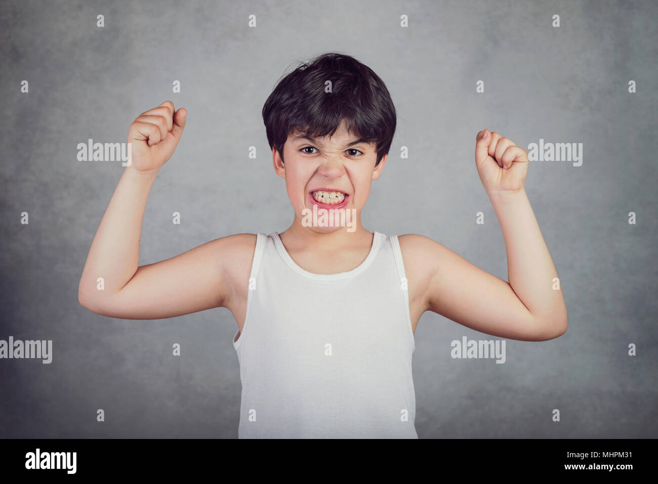 kid showing his muscles on gray background Stock Photo - Alamy