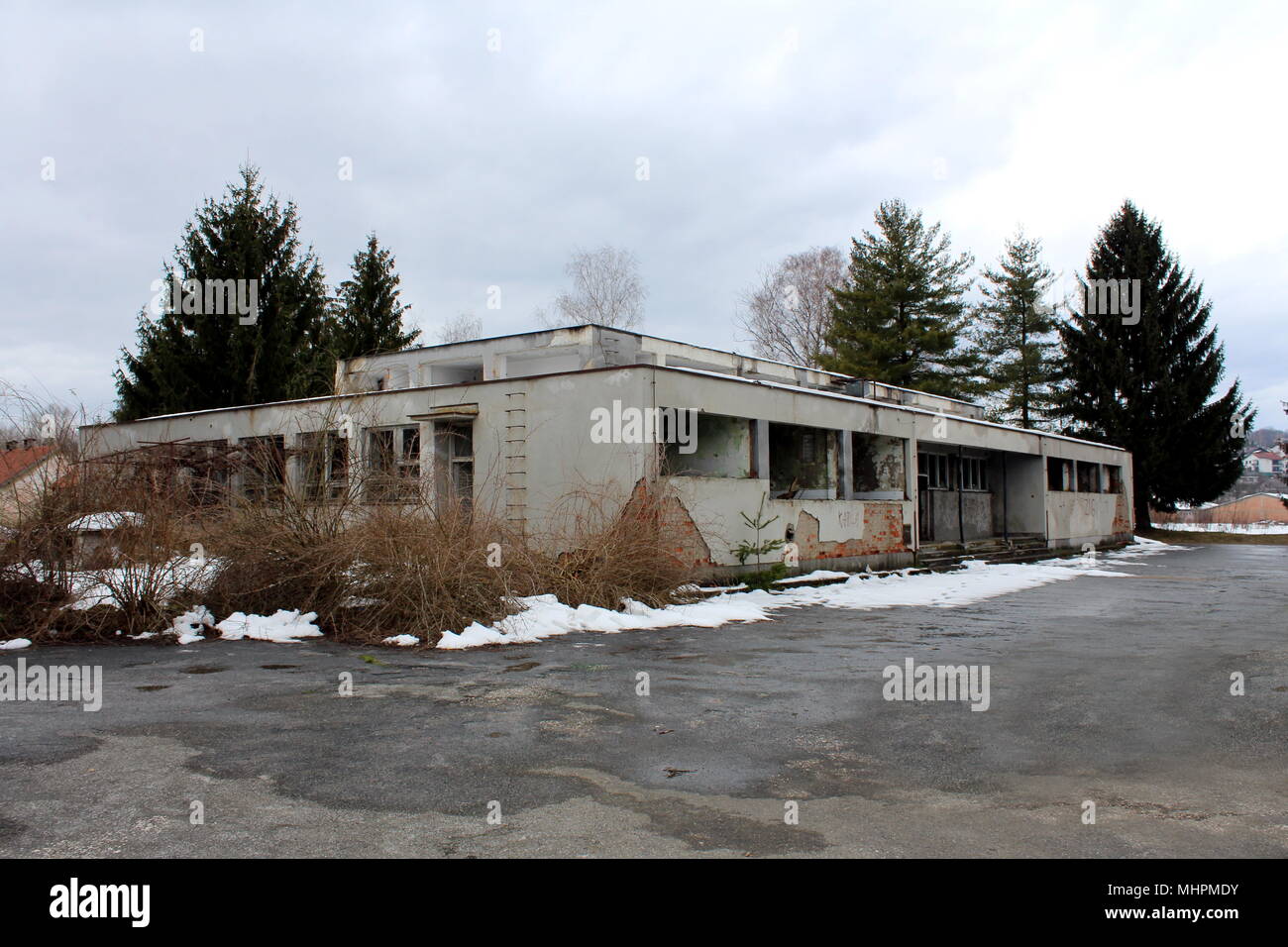 Abandoned old army building with falling facade, missing windows and ...
