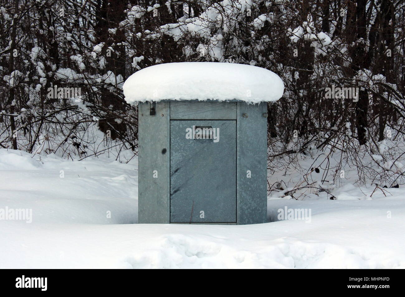 Outdoor grey metal electrical high voltage box surrounded with deep ...