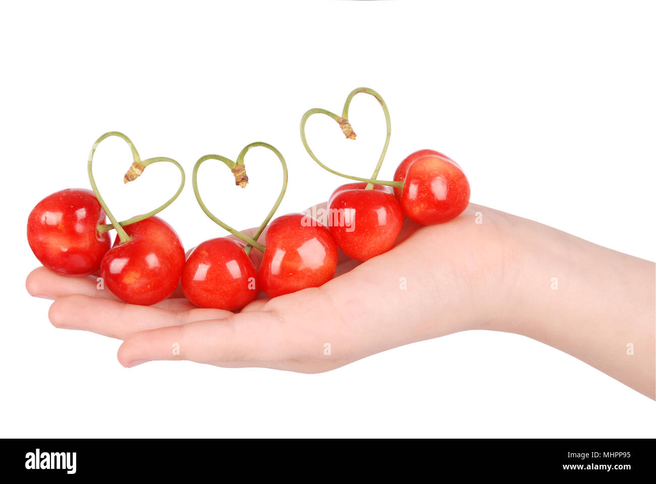Pair of sweet cherry fruits with heart shaped stem on hand isolated on ...
