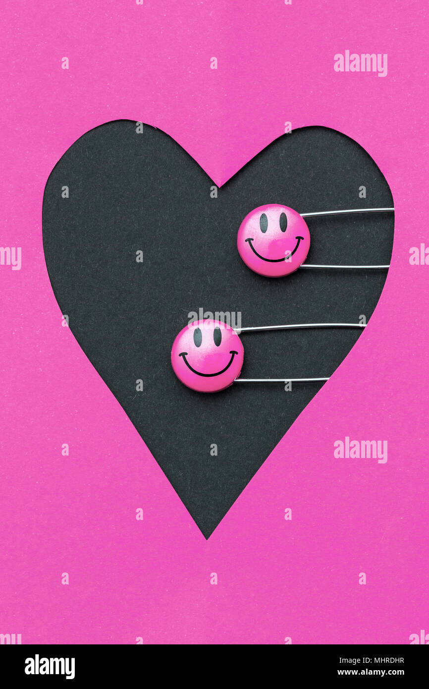 Plastic head metal safety pins pinned in heart shaped paper. Pink ...