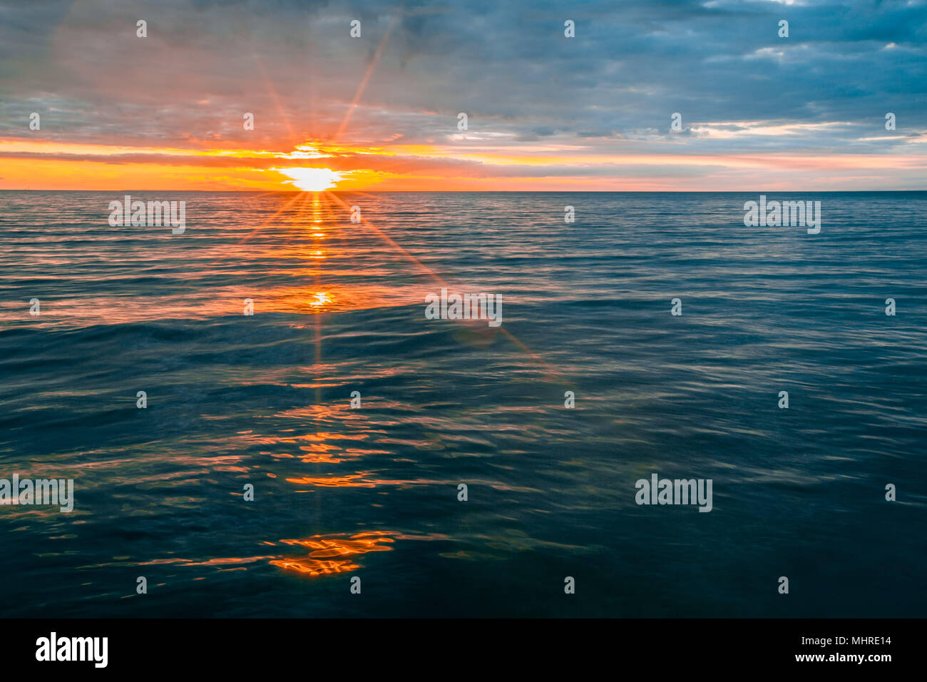Minimalist glowing sunset over calm ocean water Stock Photo - Alamy