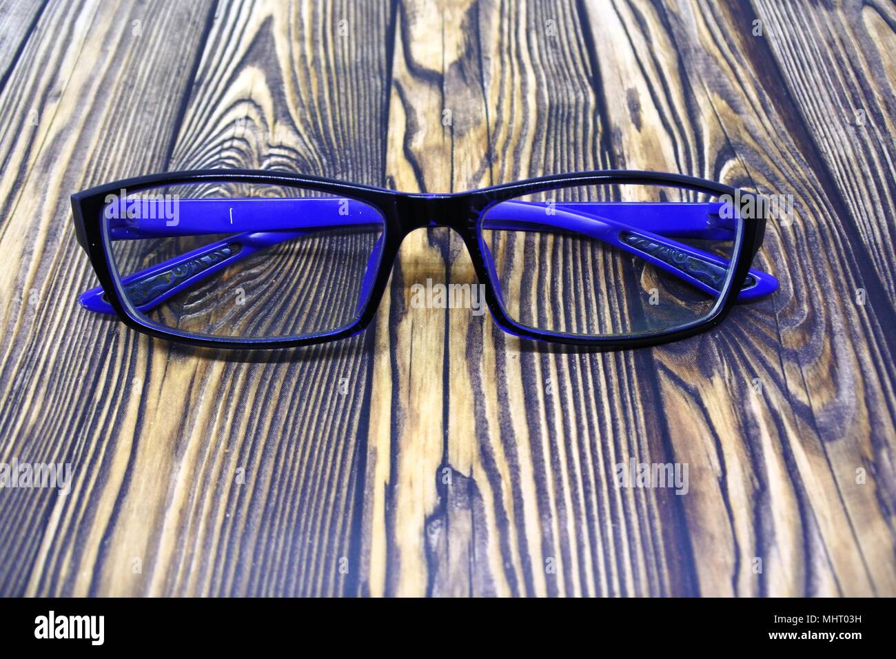 glasses with blue frame on wood background Stock Photo - Alamy