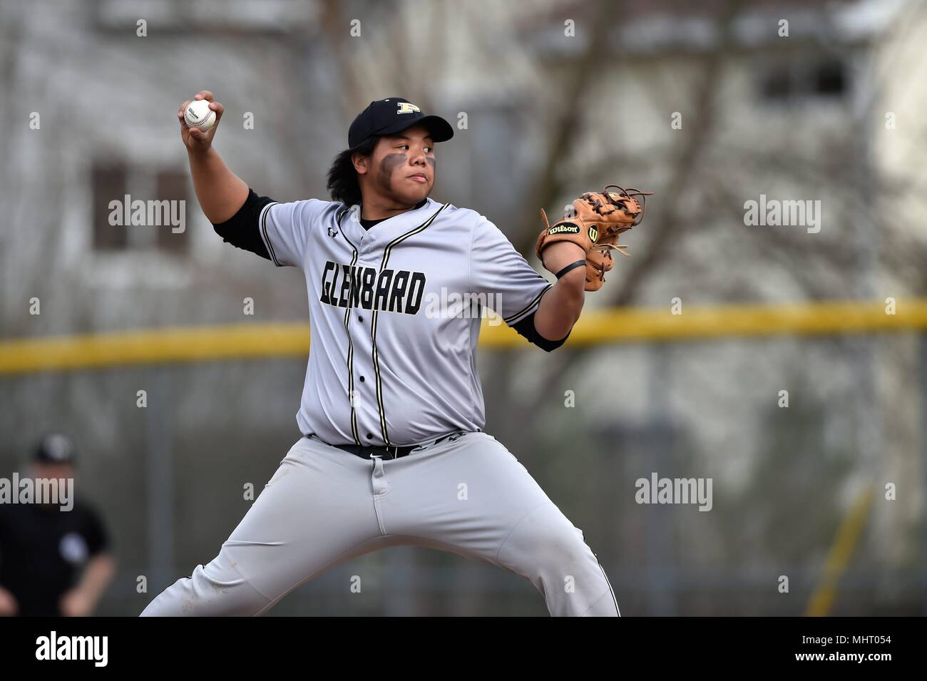 Pitcher delivering a pitch to an opposing hitter during a high school ...