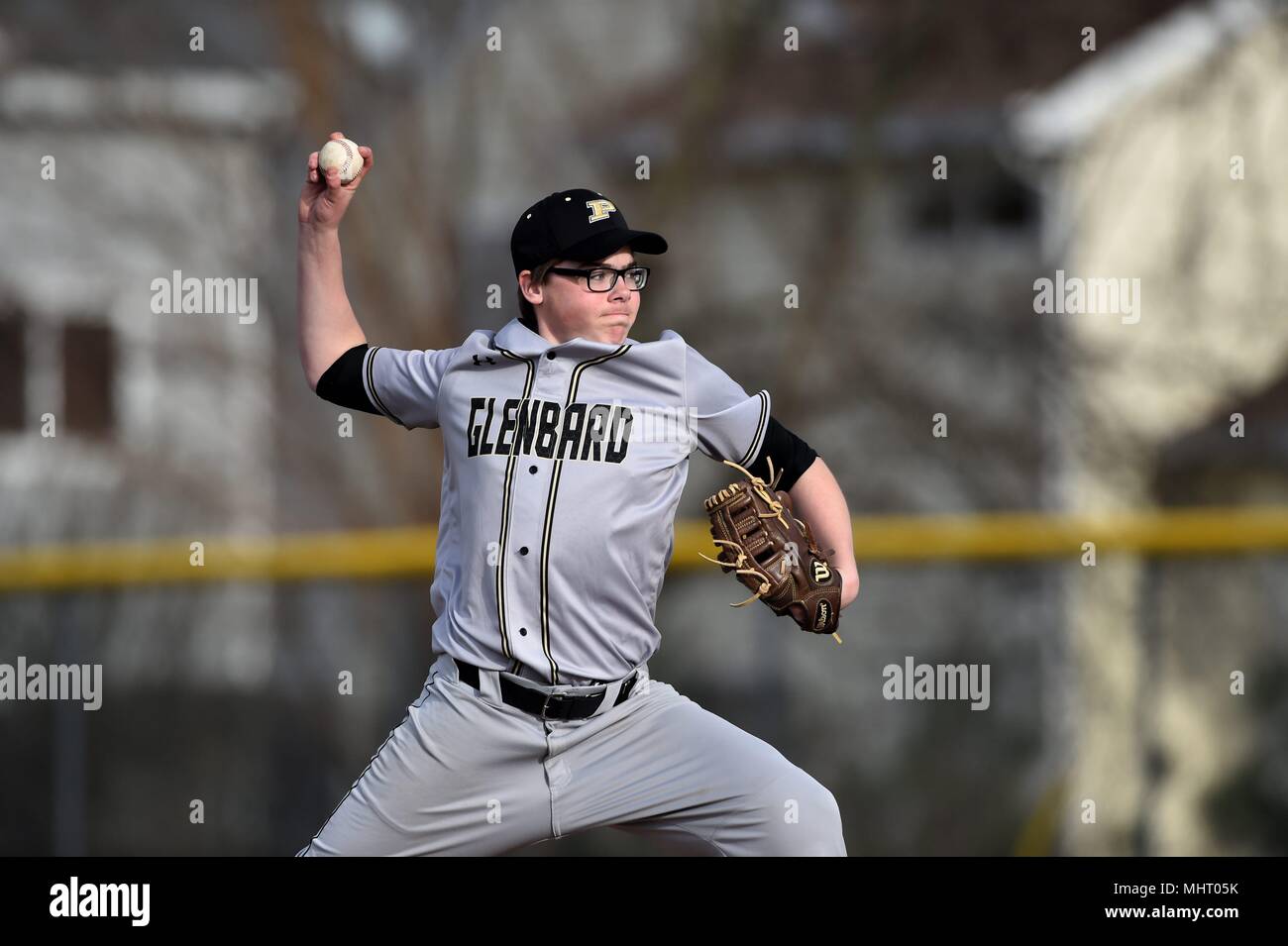 Pitcher delivering a pitch to an opposing hitter during a high school ...