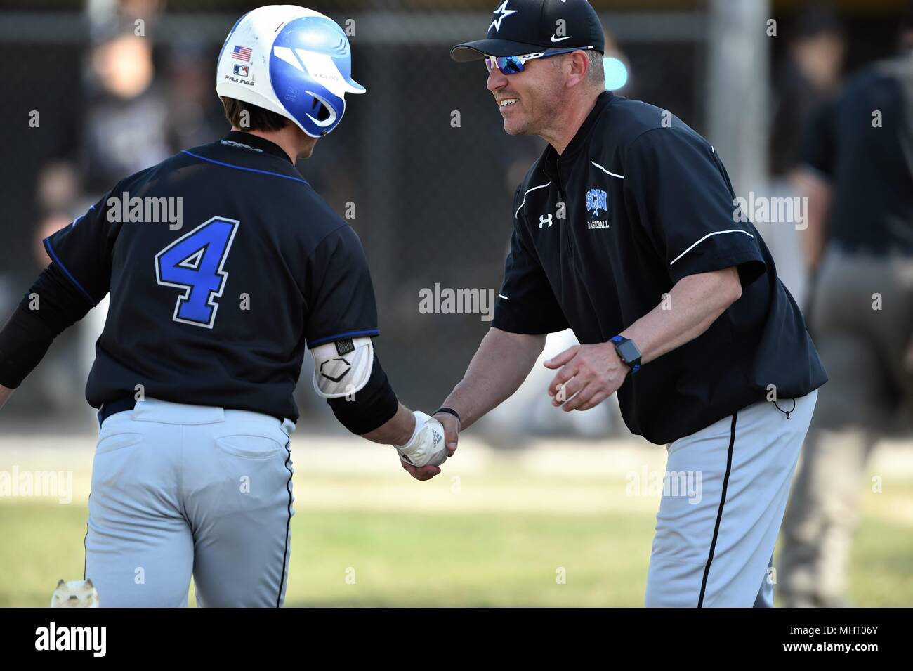 Player accepting congratulations from the third base coach on his home ...