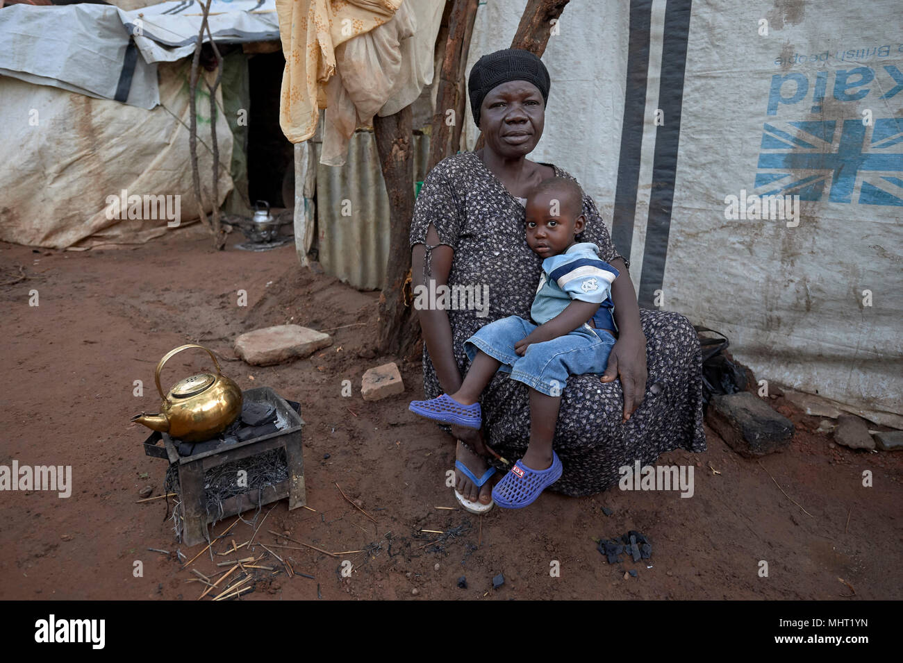 A woman displaced by war sits with a granddaughter in a camp for ...