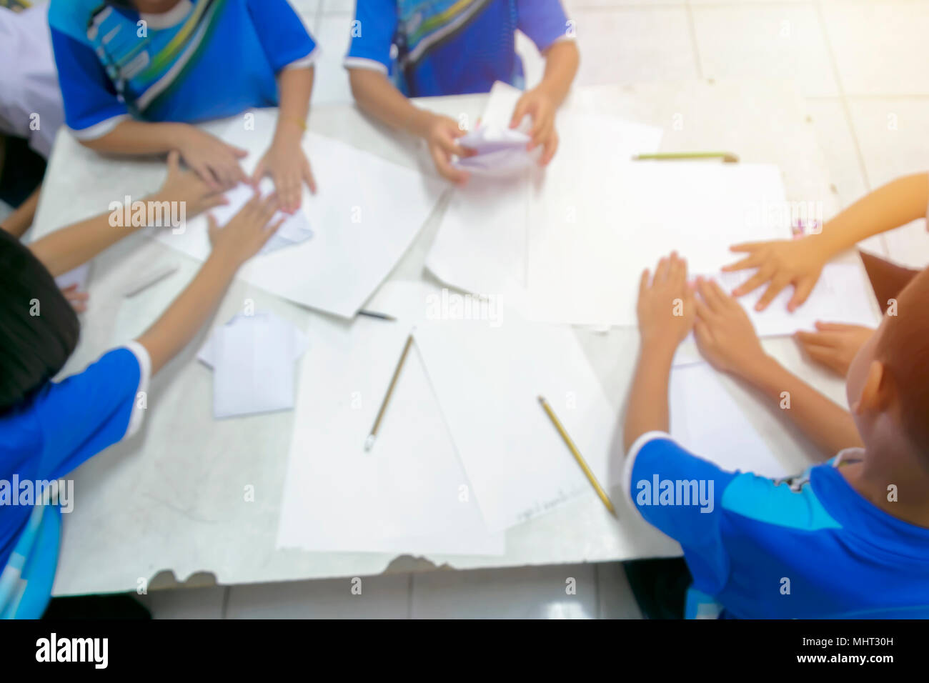 Blurred images of school children doing group learning activities ...