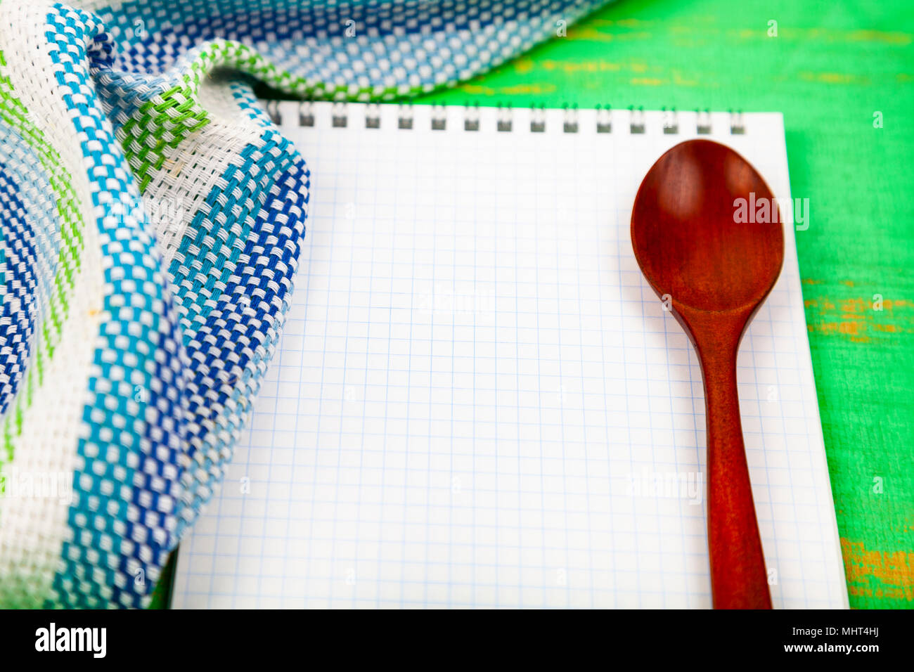 Culinary recipe, towel and spoon on a green wooden table. Cooking. Menu ...