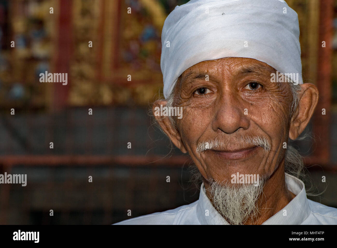 BALI, INDONESIA - AUGUST 12, 2016 - Balinese monk and worshipper with ...