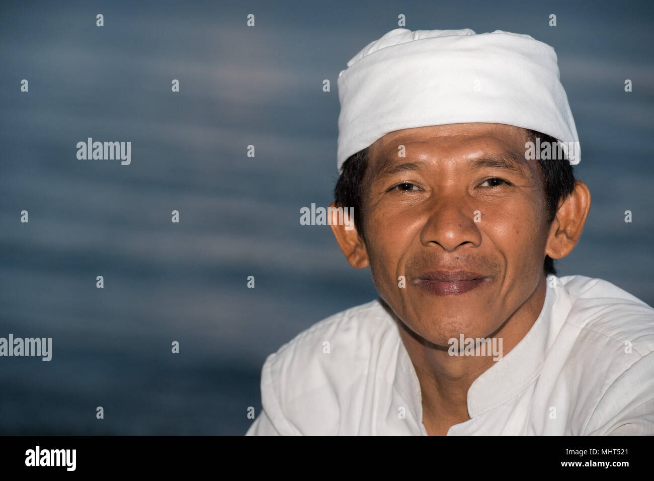 BALI, INDONESIA - AUGUST 12, 2016 - Balinese monk and worshipper with ...