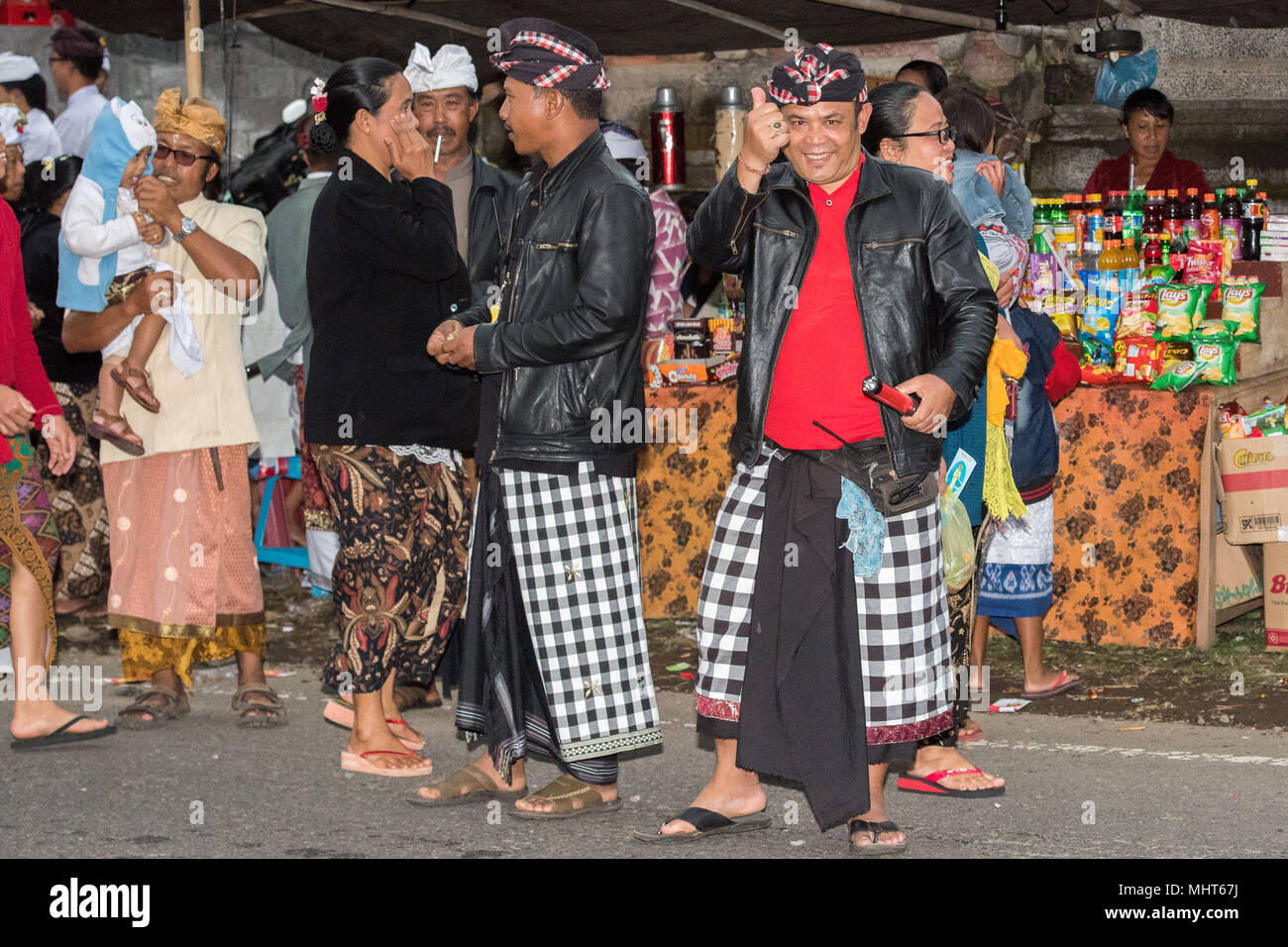 BALI, INDONESIA - AUGUST 13, 2016 - Balinese monk and worshipper with ...