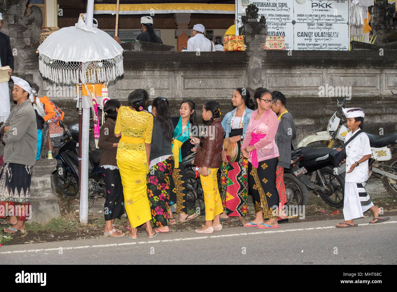 BALI, INDONESIA - AUGUST 13, 2016 - Balinese monk and worshipper with ...