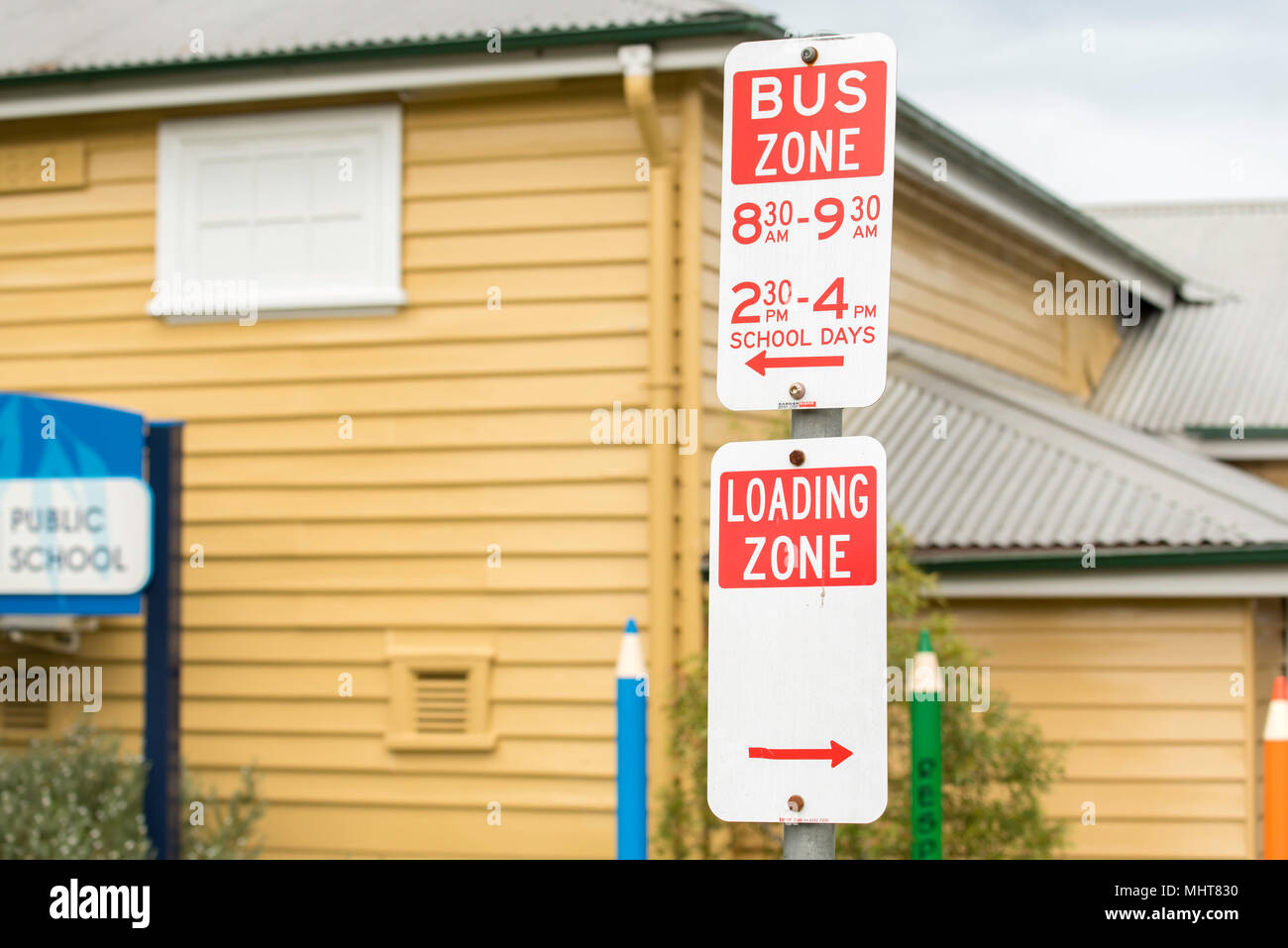 A bus zone and loading zone sign outside the public (Primary) school in ...