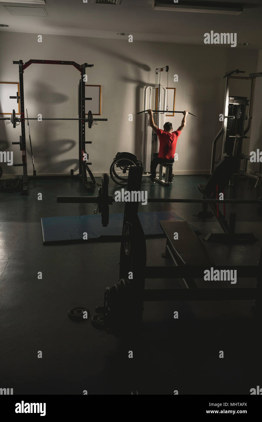 Handicapped man working out lat pulldown training Stock Photo - Alamy